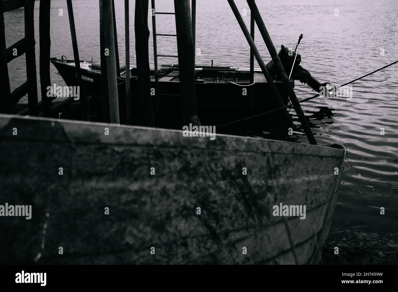 Grayscale of an old boat on a lake Stock Photo - Alamy
