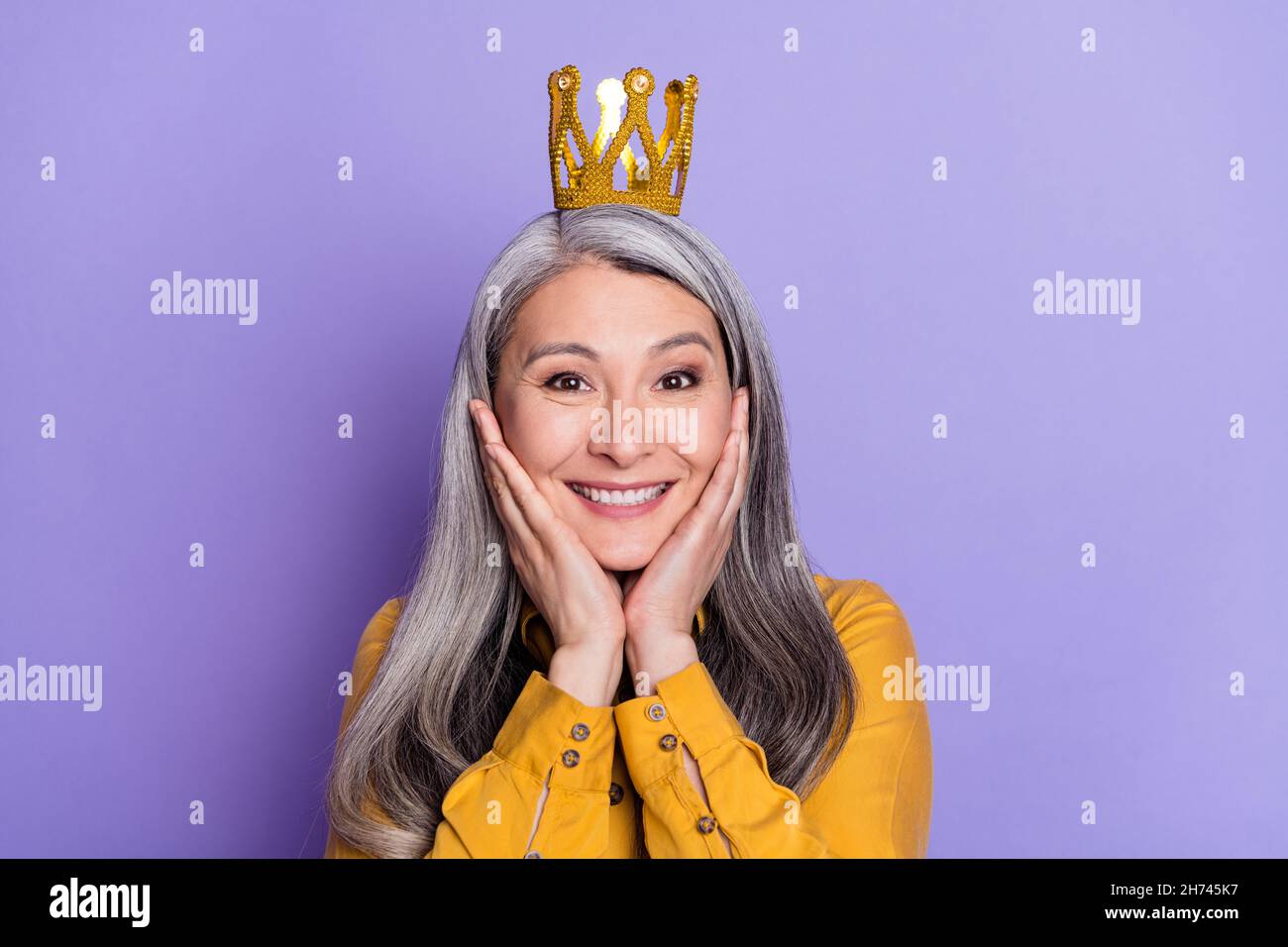 Portrait of attractive cheerful impressed woman wearing crown enjoying ...
