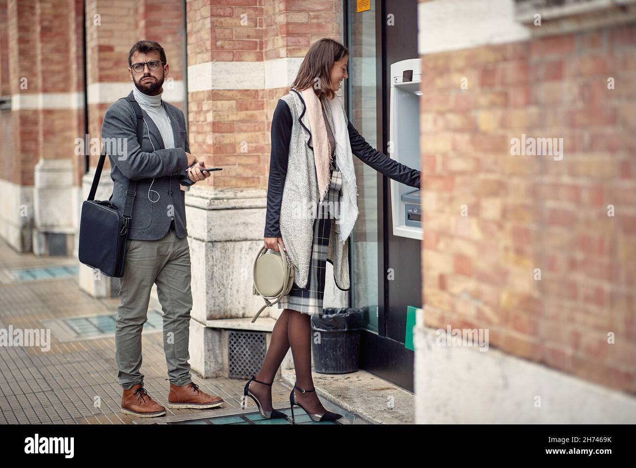 A young elegant man is nervous while impatiently waiting in a row for ...