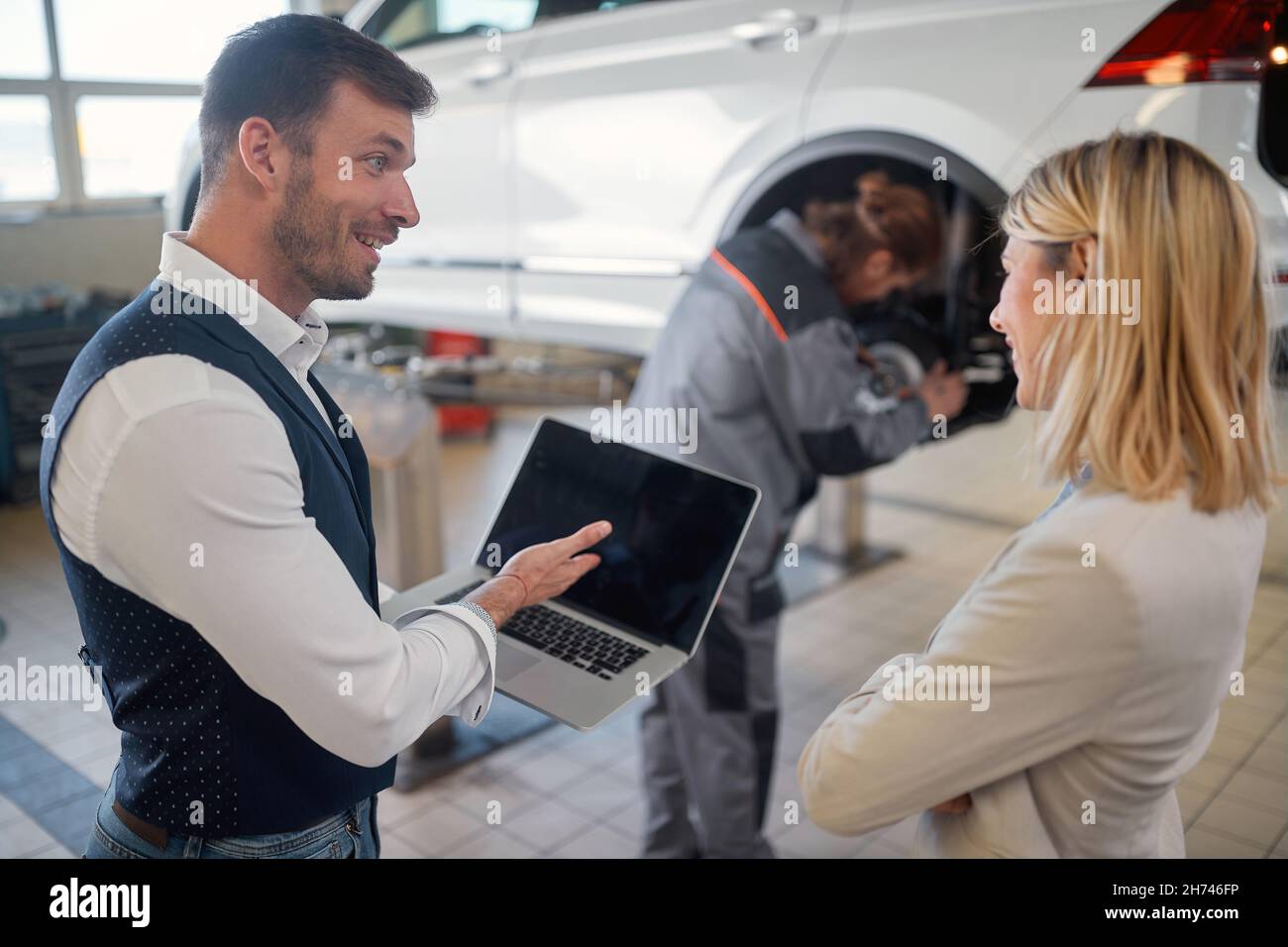 Client and employee looking diagnostic on engine car Stock Photo - Alamy