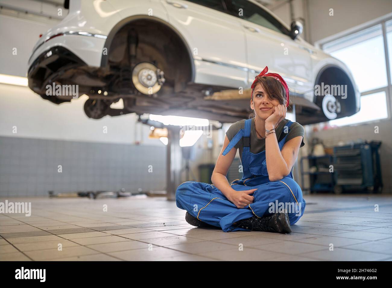 mechanic woman working on a car in an auto repair shop. Female mechanic ...