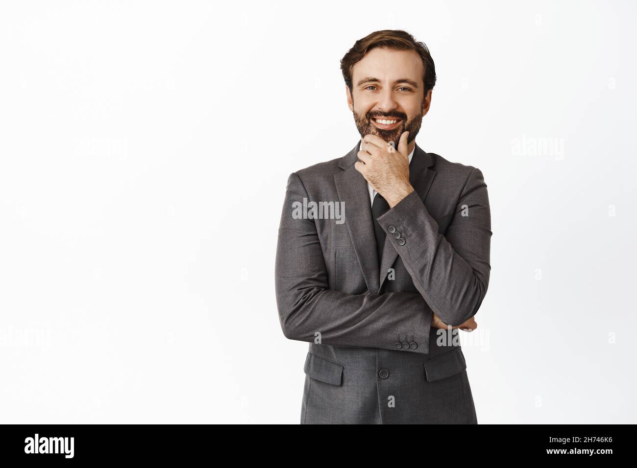 Handsome corporate man in suit looking pleased, smiling and touching ...