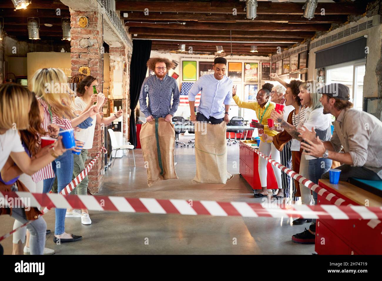 Group of work colleagues having fun competition together at the office ...