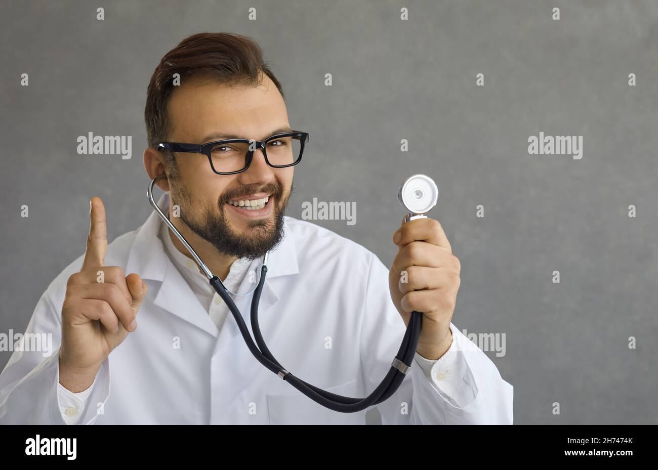 Close up of a smiling male doctor with a sly expression showing that he ...