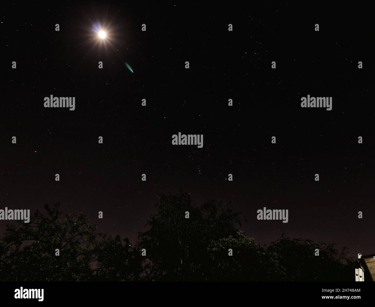 Dark summer evening outdoors with the moon and the stars shining above ...