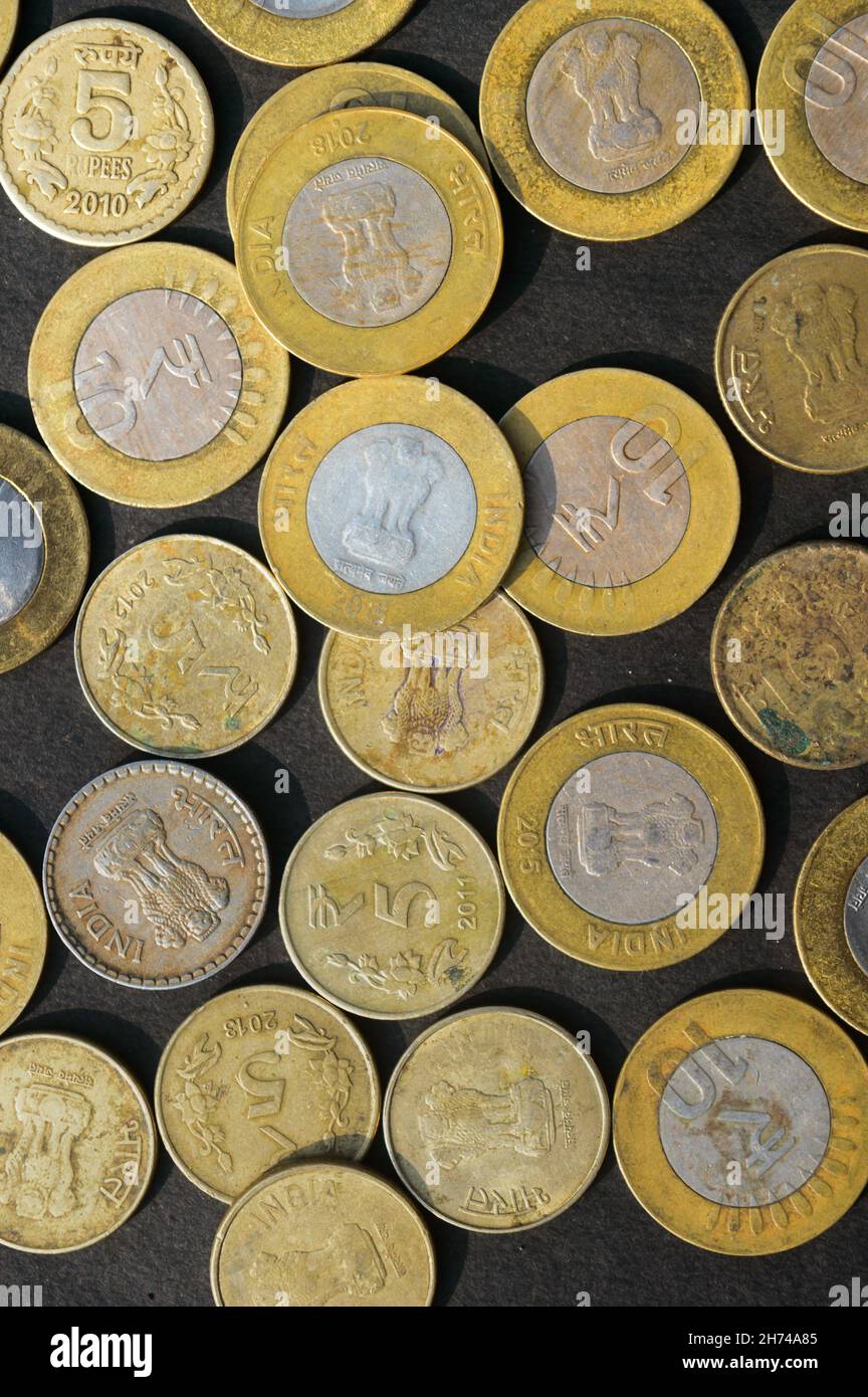 Mix of Gold Colored Indian Rupee Coin currency on rustic floor. Full ...