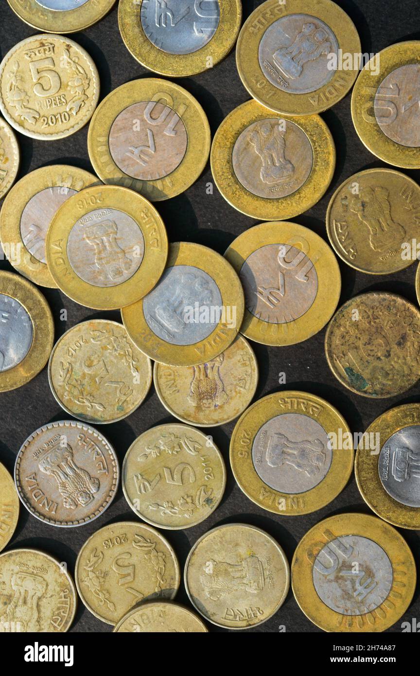 Mix of Gold Colored Indian Rupee Coin currency on rustic floor. Full ...