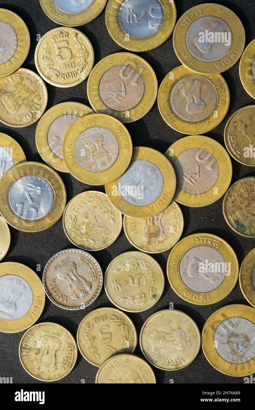 Mix of Gold Colored Indian Rupee Coin currency on rustic floor. Full ...