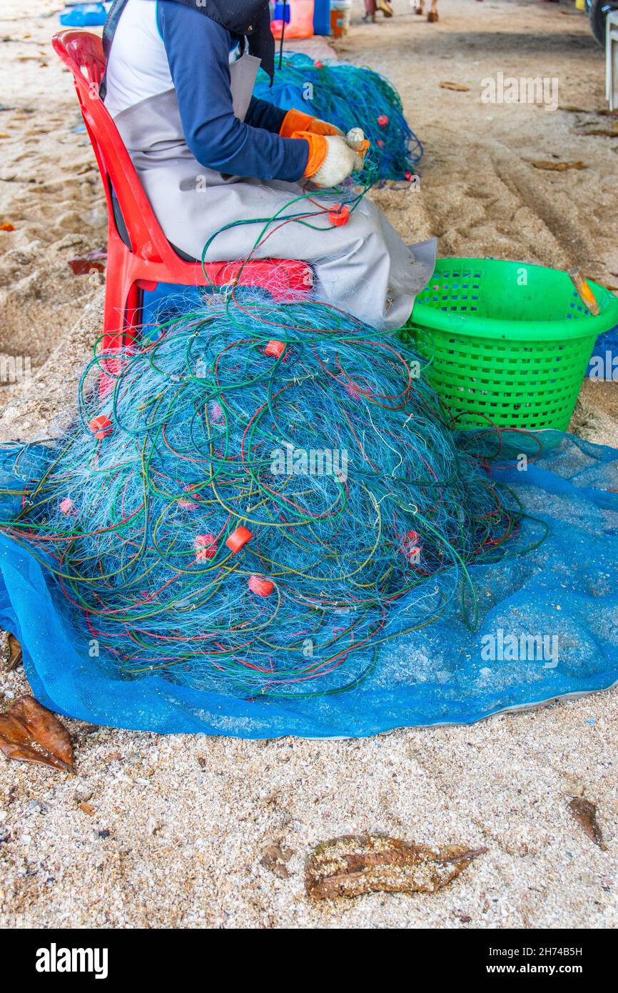Repair and inspection of a fishing net at the beach Stock Photo - Alamy