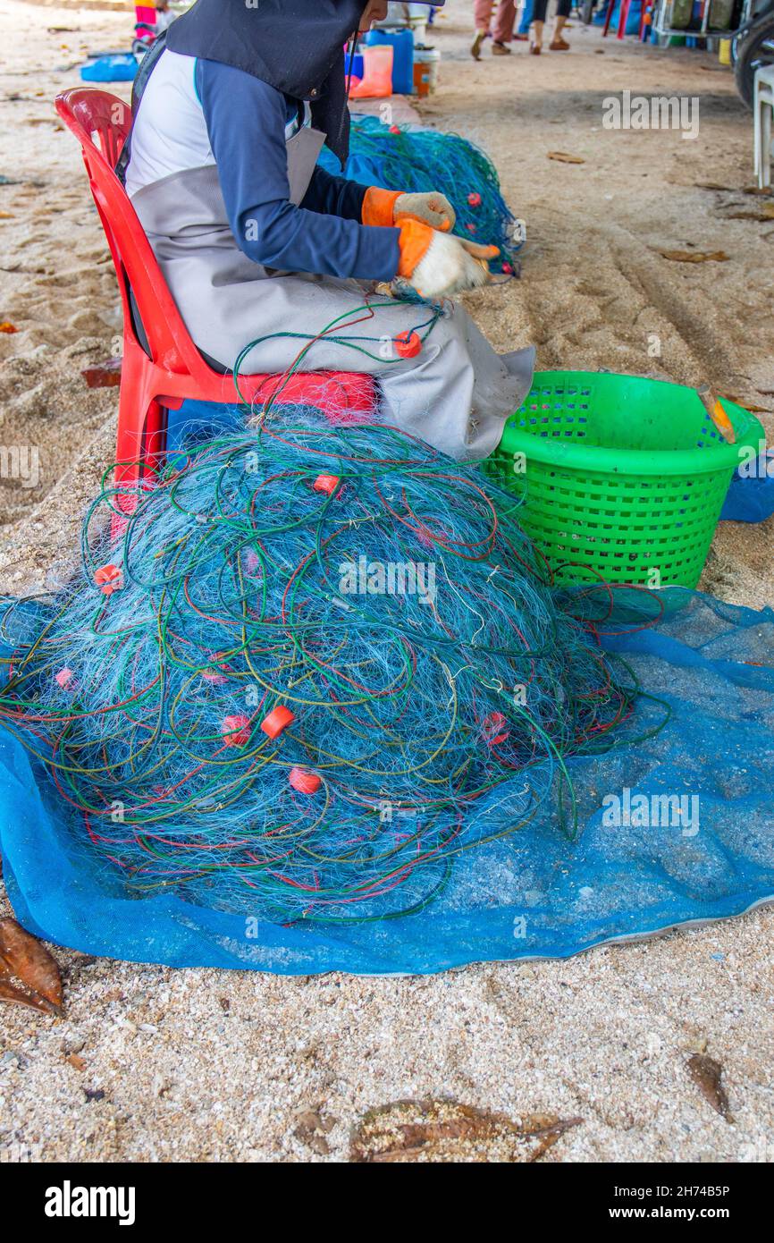 Repair and inspection of a fishing net at the beach Stock Photo - Alamy
