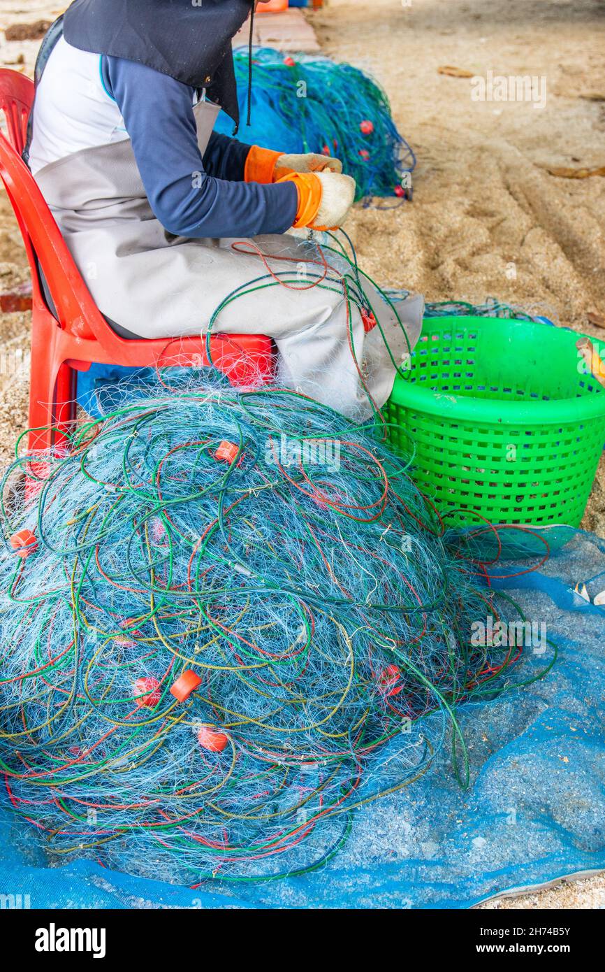 Repair and inspection of a fishing net at the beach Stock Photo - Alamy