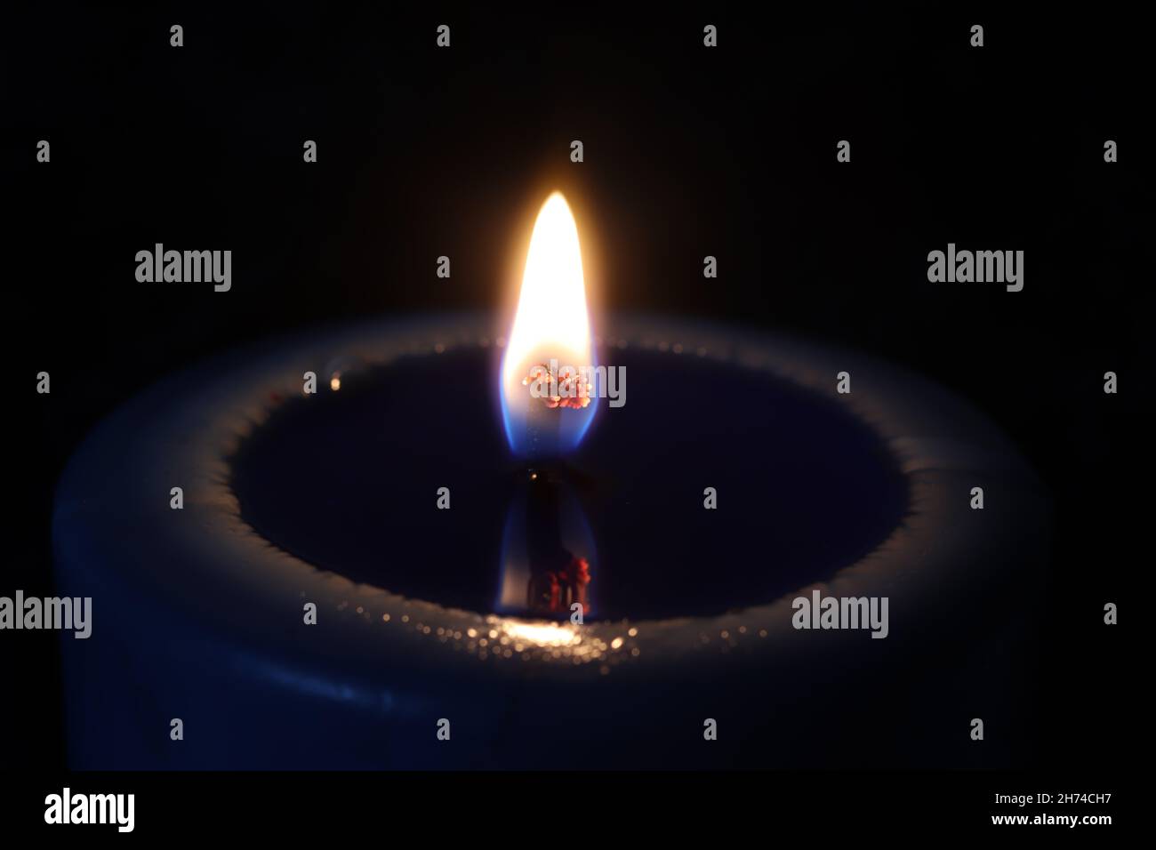 Single lit candle with quite flame on black background Stock Photo - Alamy