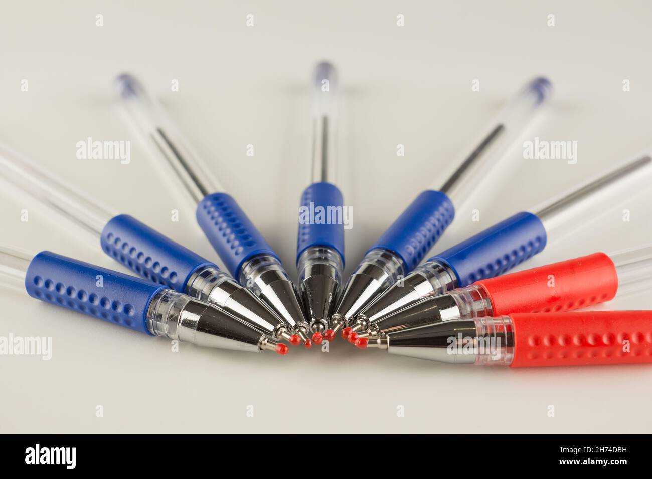 set of blue ballpoint pens lined up by an arc on a white background ...