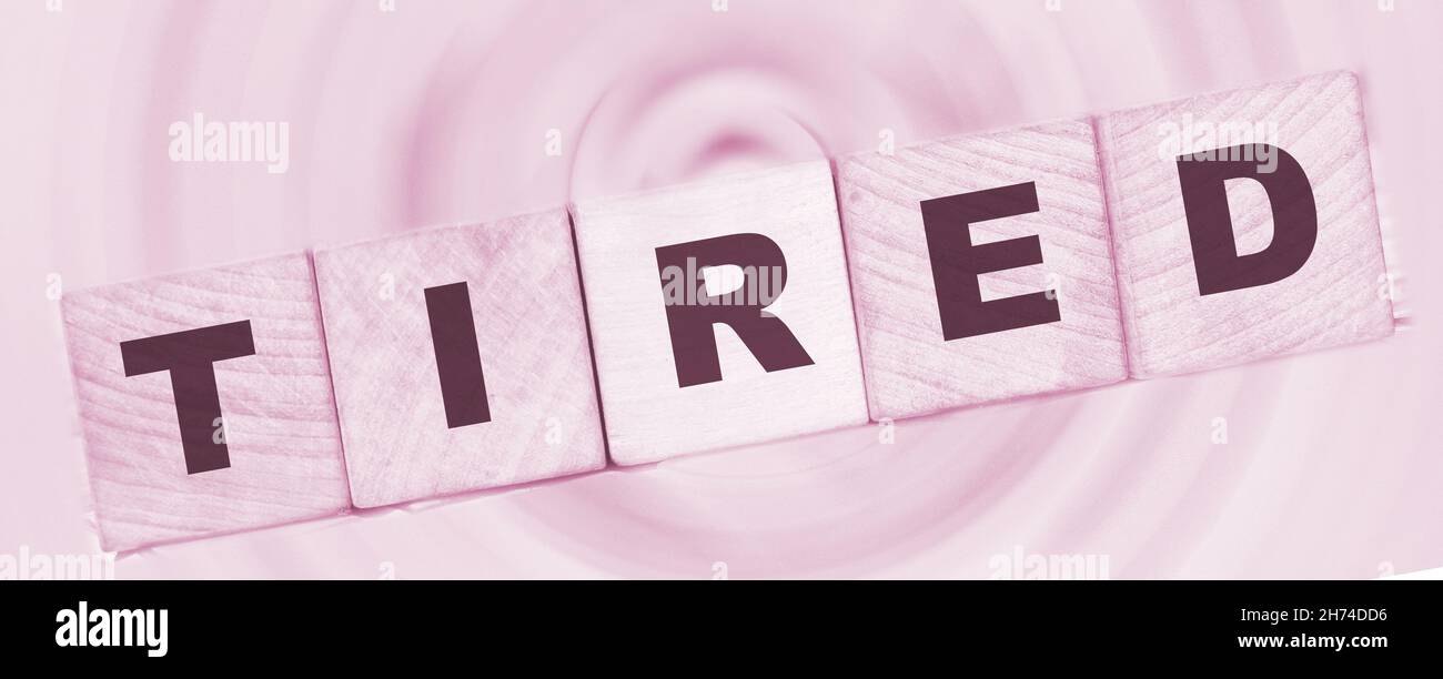 Tired word on wooden cubes on relaxed beach background. Relax vacation ...