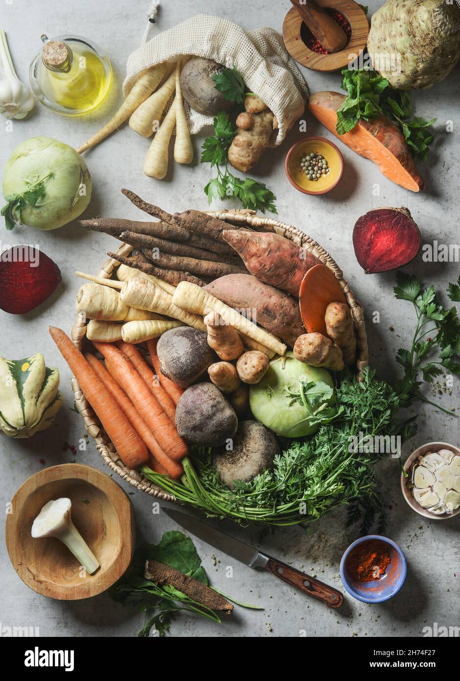 Various raw root vegetables and other ingredients on concrete kitchen ...