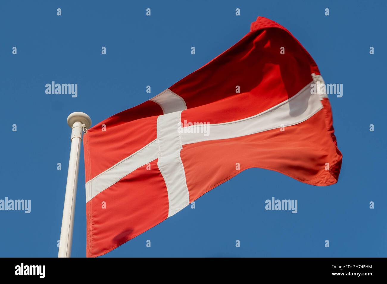 Denmark Flag hanging and blowing in sunshine on blue sky background ...