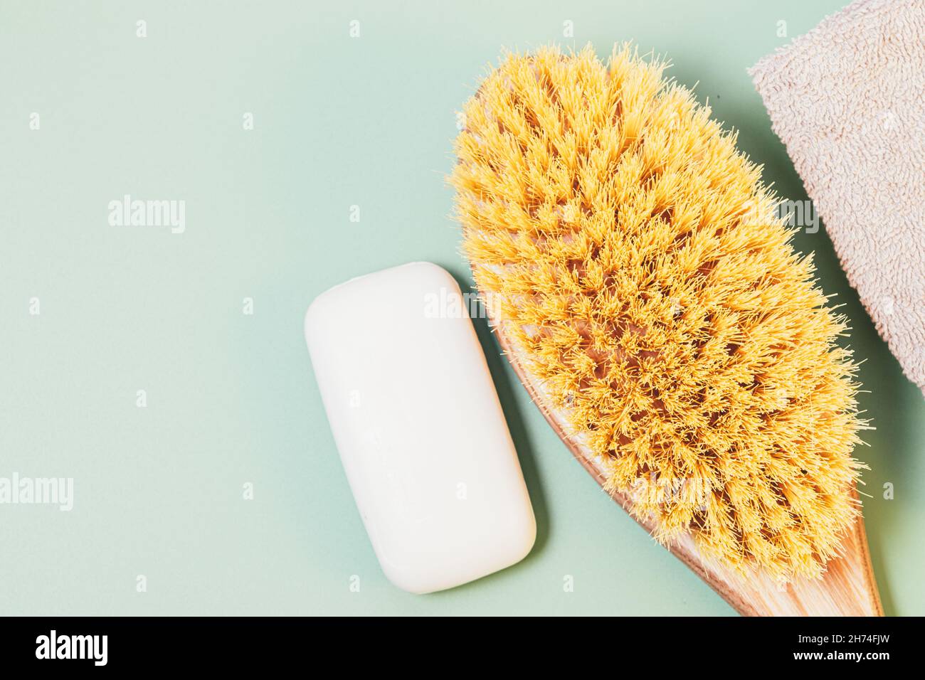 Simple hygiene bath setting with massage brush, bar of soap and towel ...