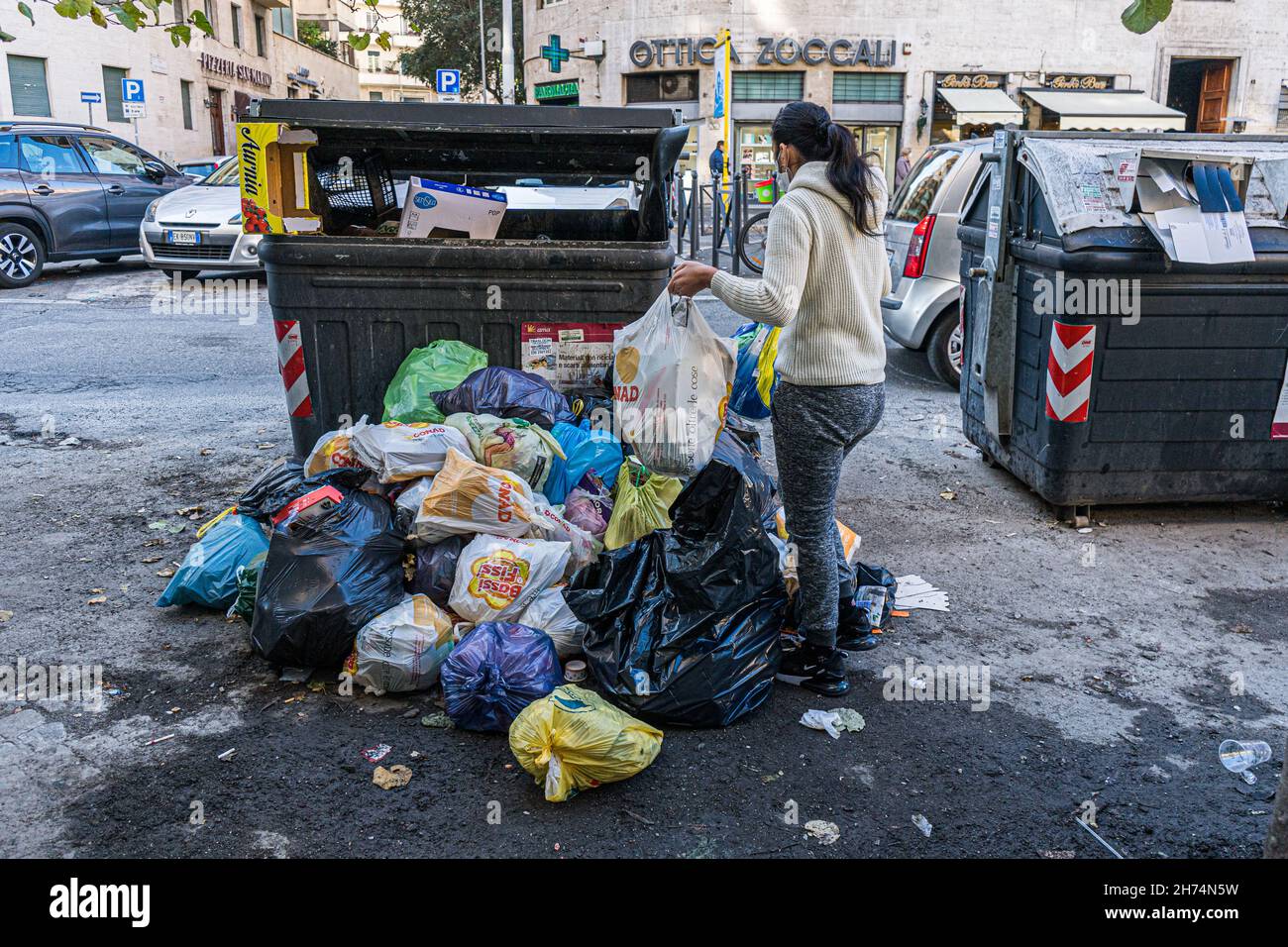 Rome, Italy. 20 November 2021. A woman brings her rubbish bags to a ...