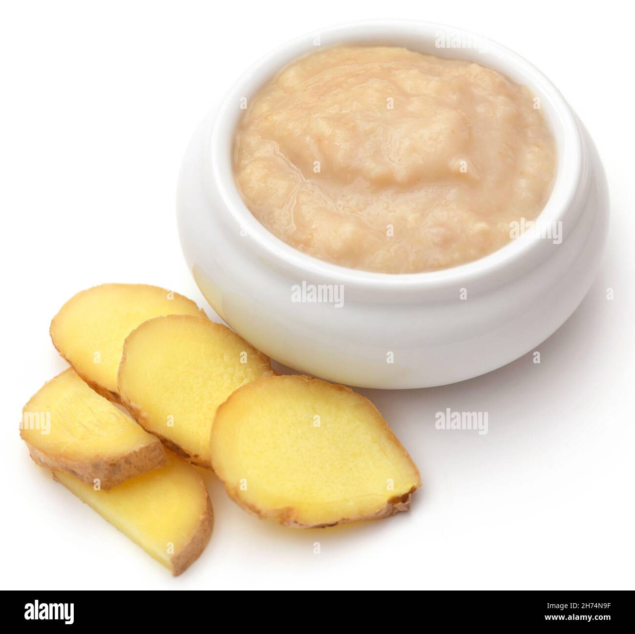 Ginger with paste over white background Stock Photo - Alamy