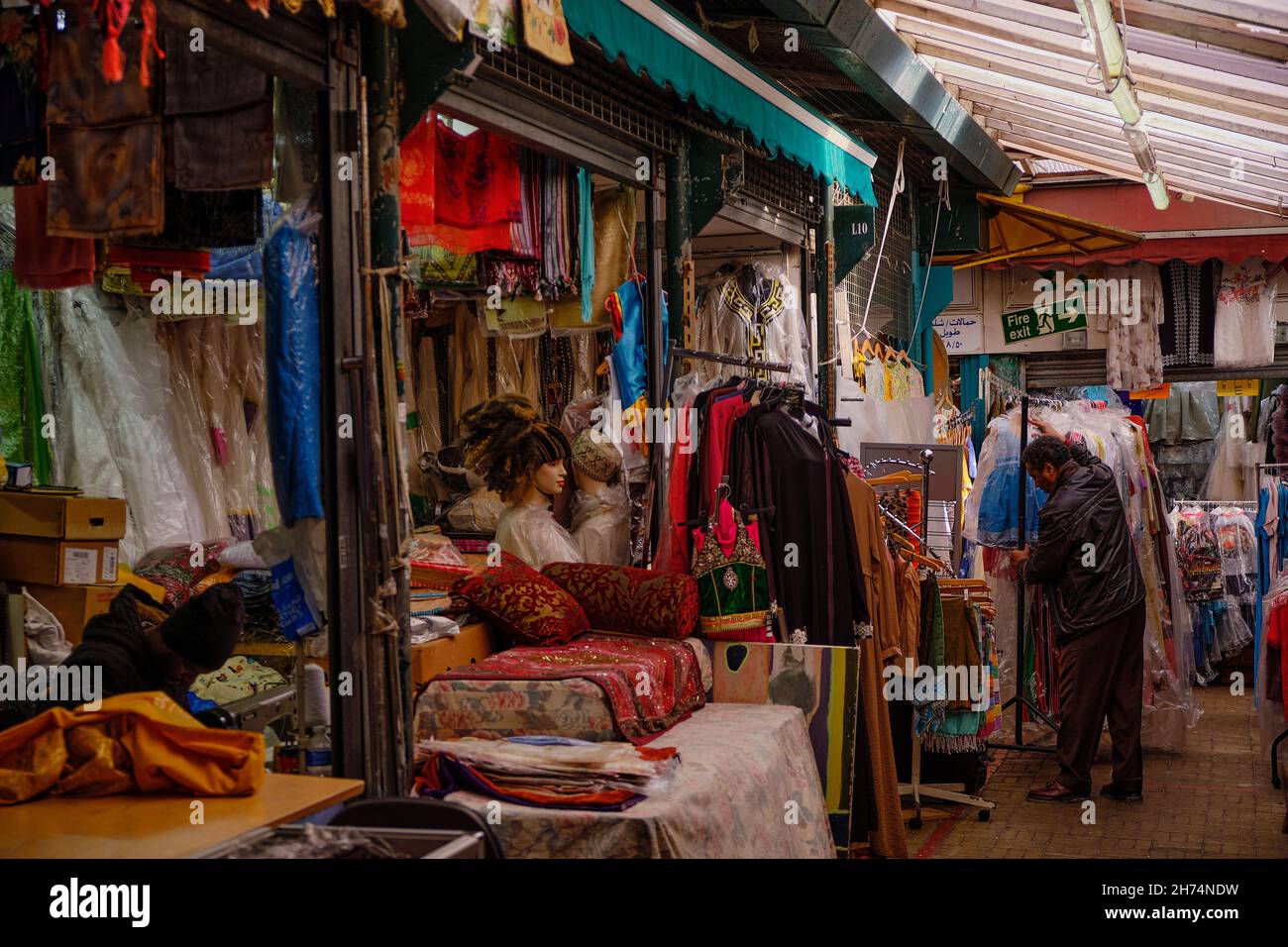 Man moving clothes rack inside Shepherd's Bush market in London Stock ...