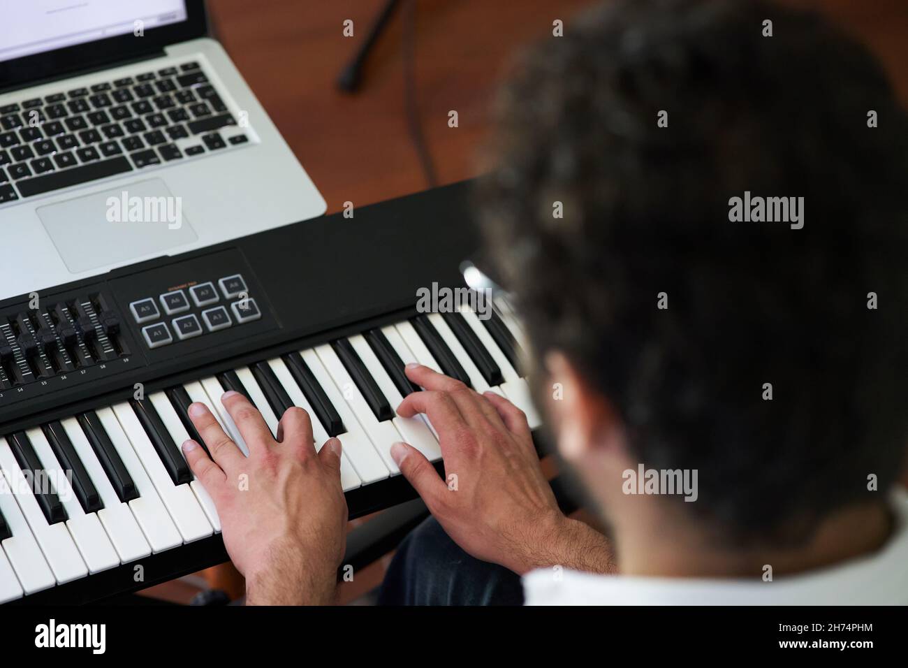 musician plays piano in front of his computer Stock Photo - Alamy