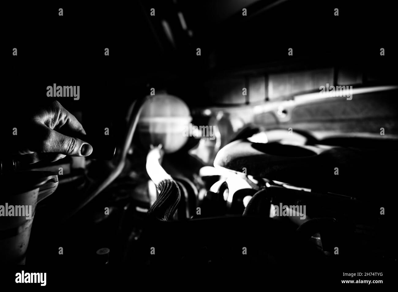 Shining a light into the open hood of vehicle to check the engine Stock ...