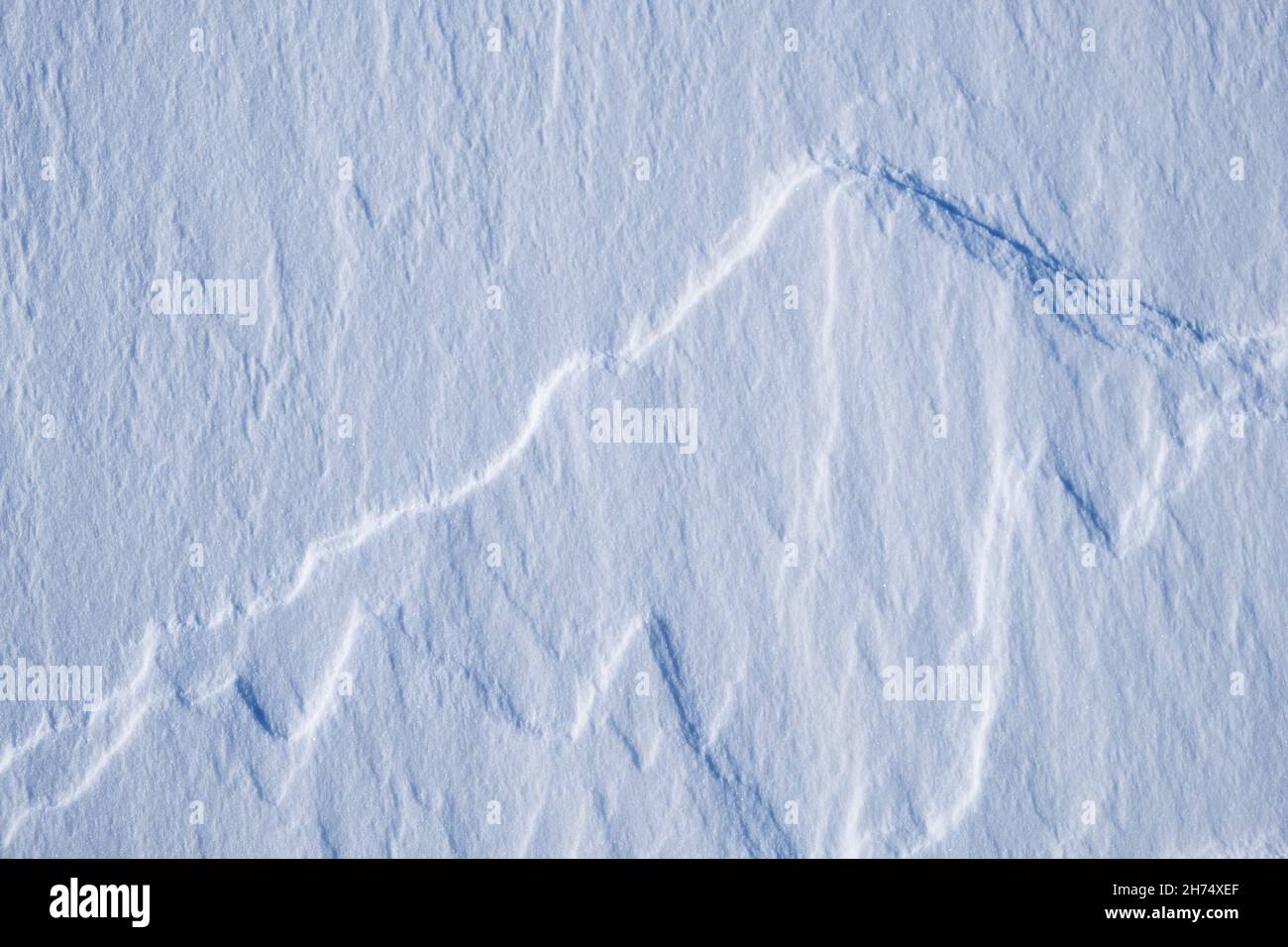 Natural snow background with drawings of mountains made by the wind ...