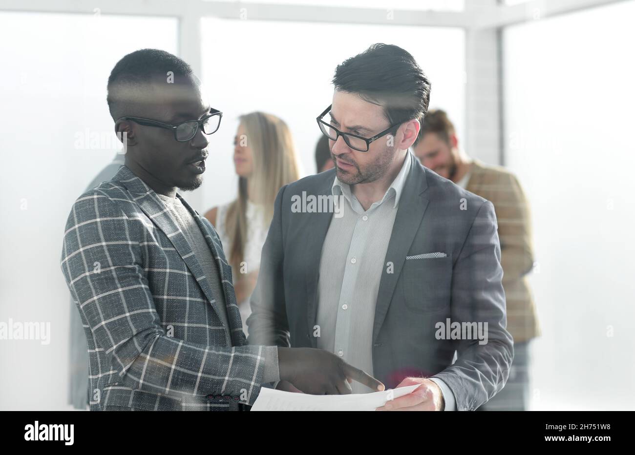 business colleagues discussing a working paper Stock Photo - Alamy
