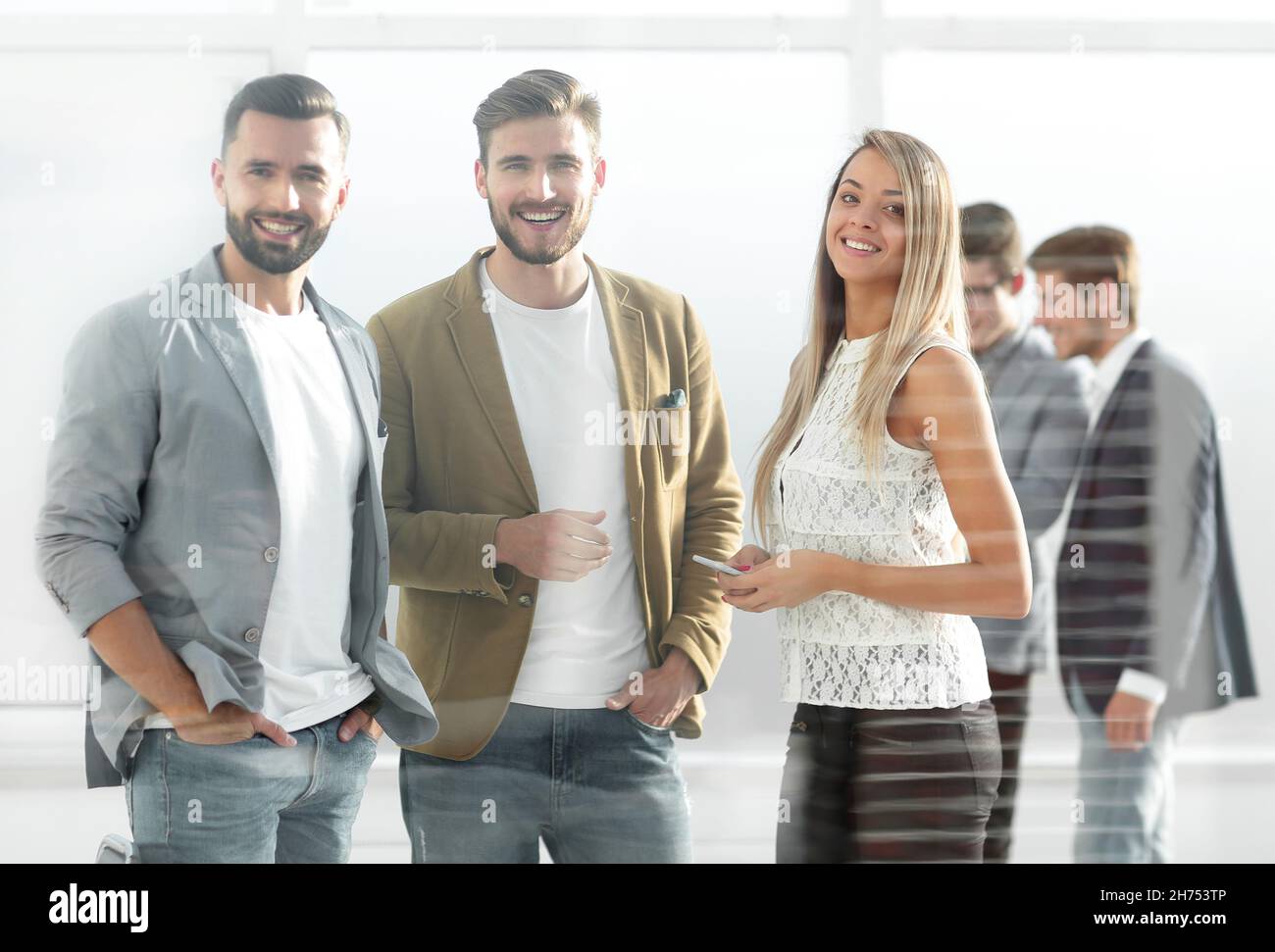 three young employees of the company standing in the office Stock Photo ...