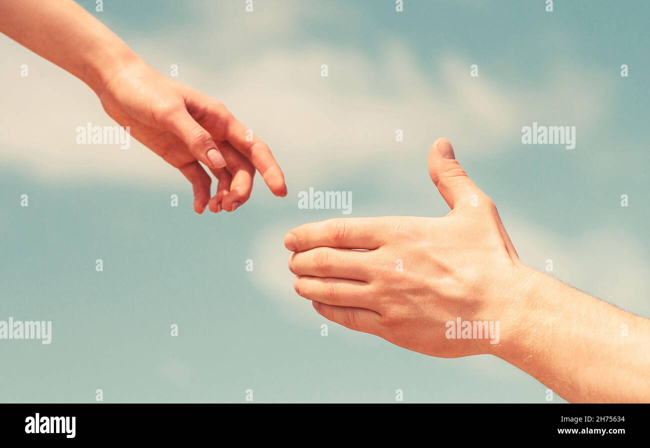 Giving a helping hand. Hands of man and woman on blue sky background ...