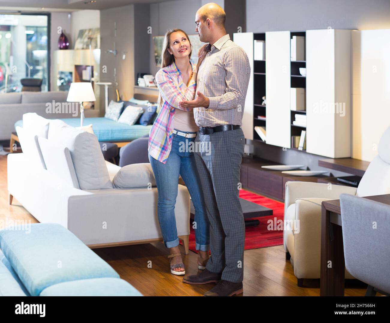 Family couple visiting salon of furniture in search of new couch Stock ...