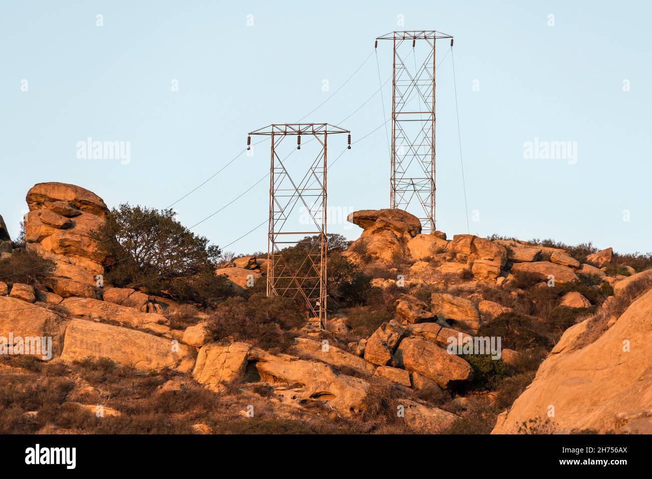 Early morning view of old electric power towers crossing dry mountains ...