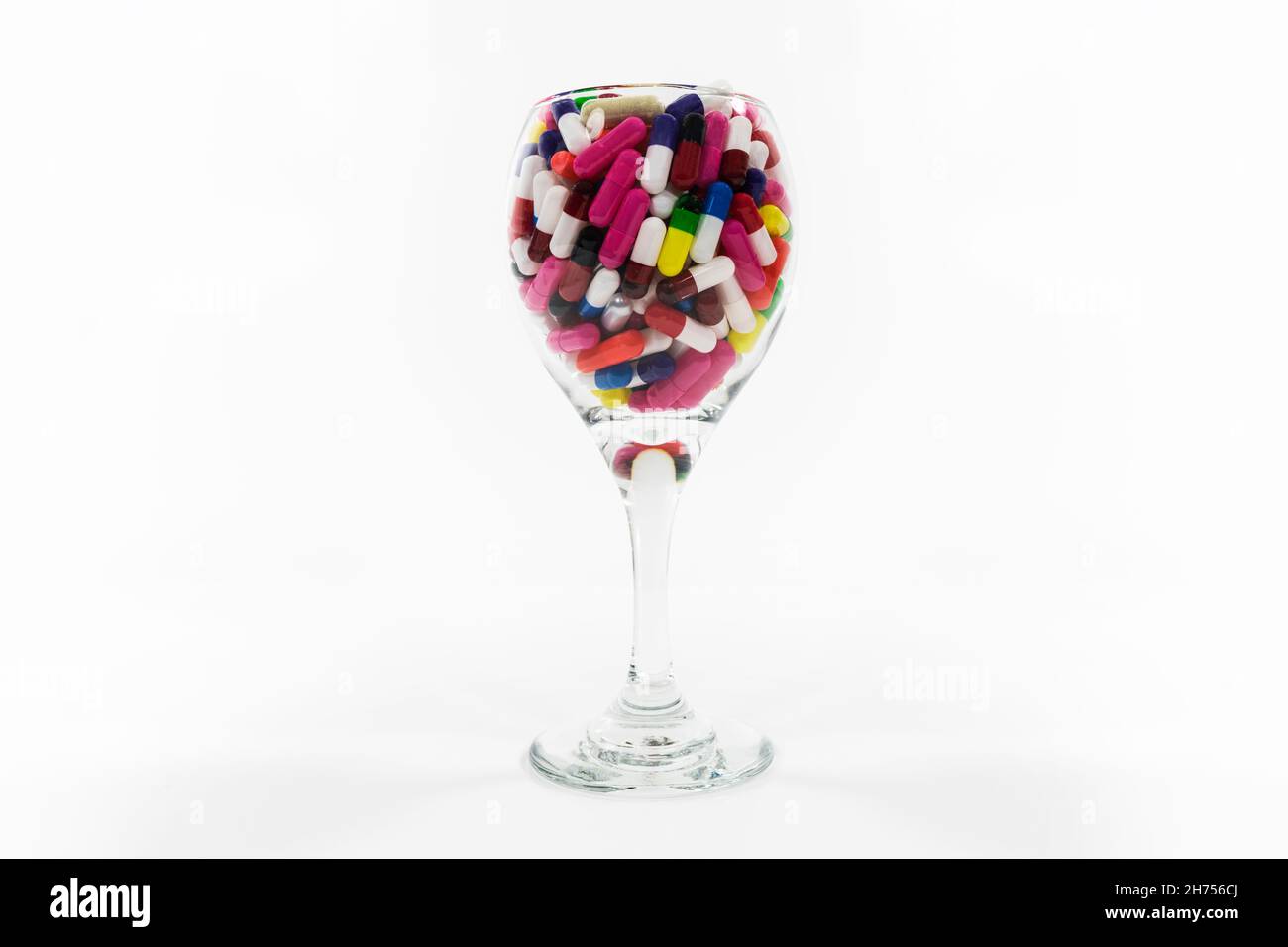 Wine glass filled with pills and capsules on white background Stock ...