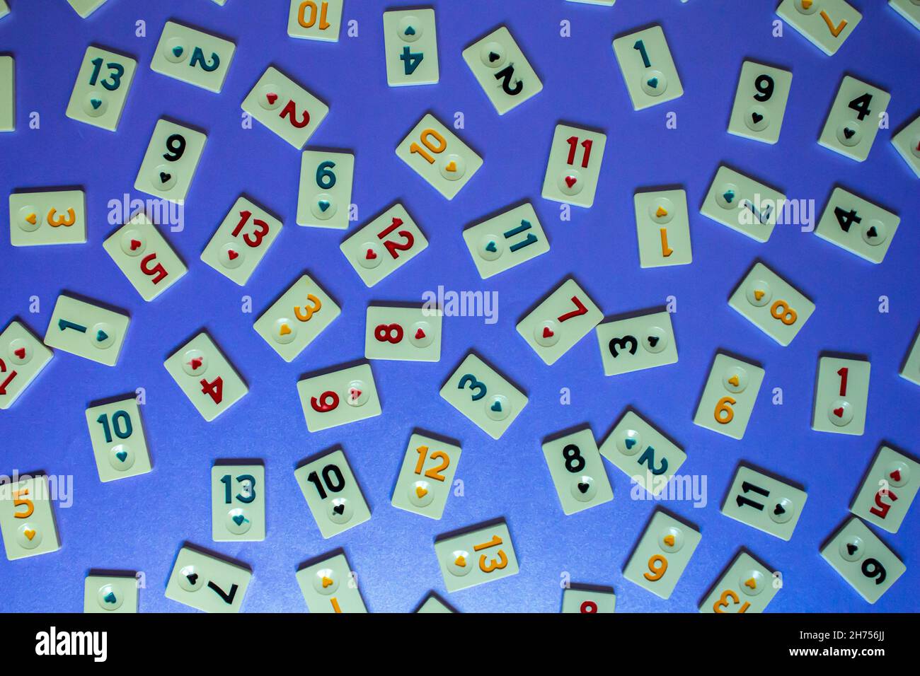 Rummikub game tiles, top view of rummikub tiles isolated on navy blue background. Numbers ...