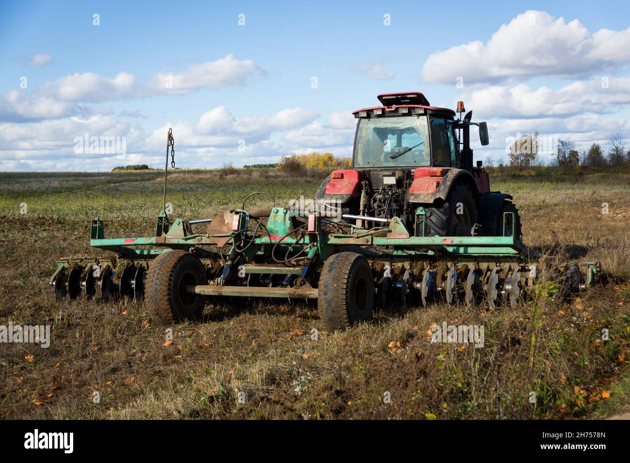 Plowing a heavy tractor while cultivating agricultural work in a field ...