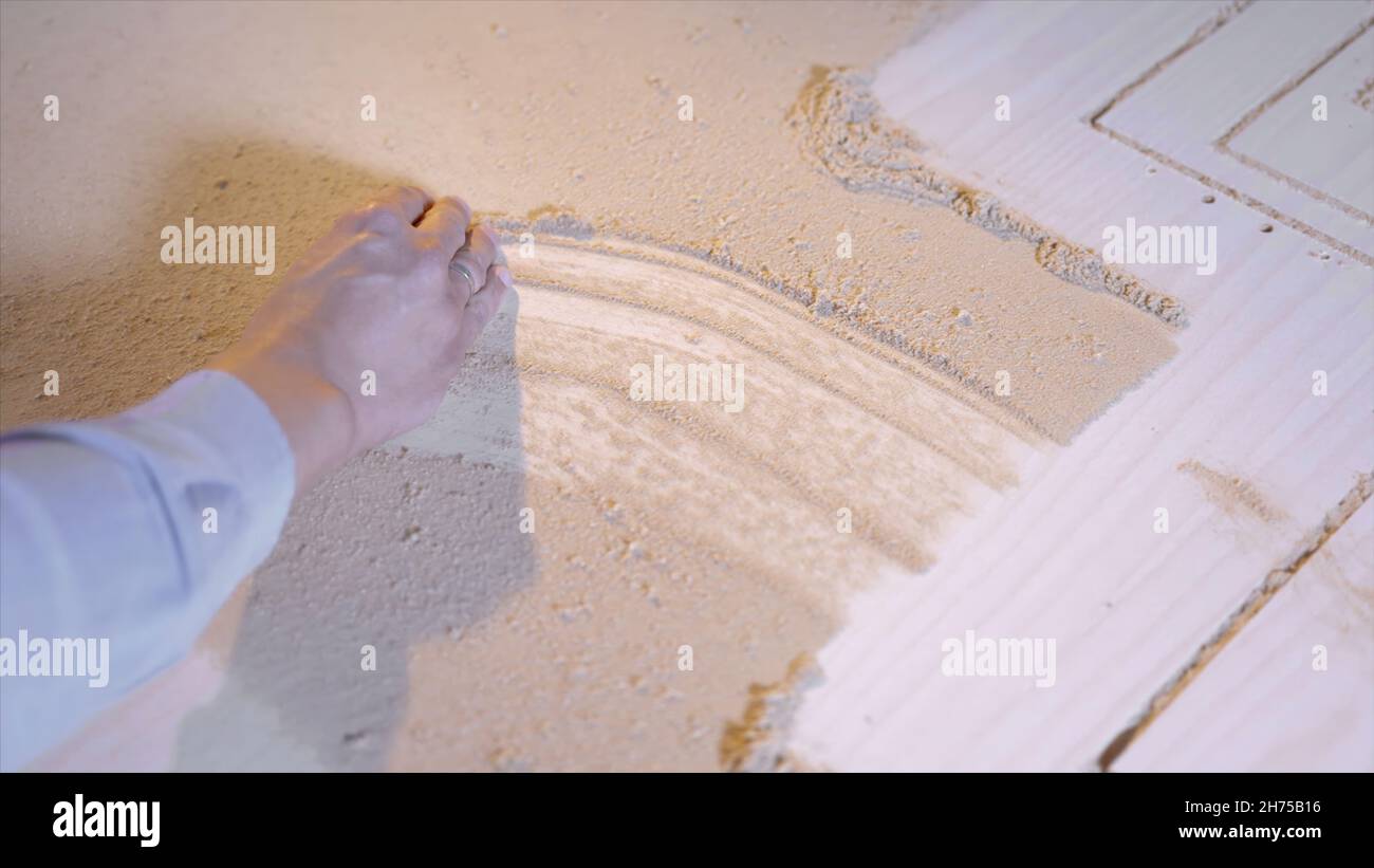 Hand carpenter takes wood dust. Action. Hand wipes table covered with ...