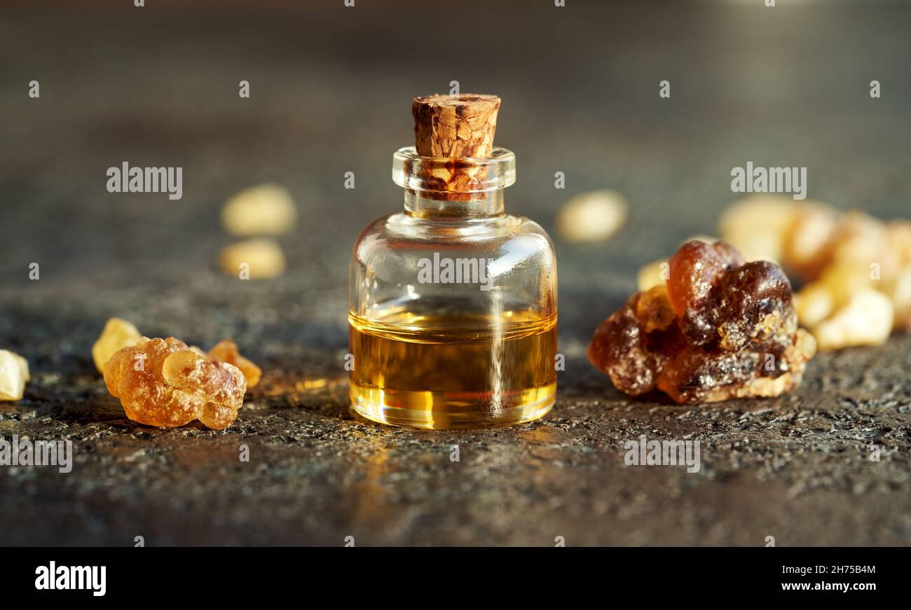 A glass bottle of essential oil with frankincense resin crystals Stock ...