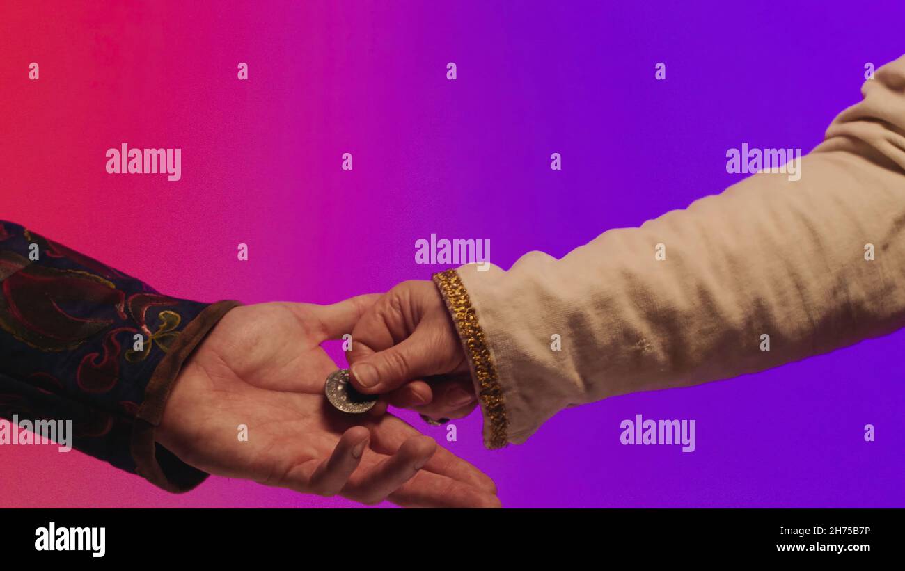 Man in medieval clothes gives a coin. Stock. Concept of trade in the ...