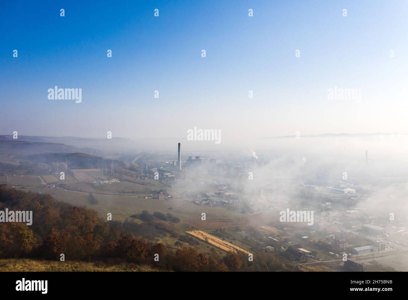 Industrial landscape with chimneys tank in morning mist. Pollution ...