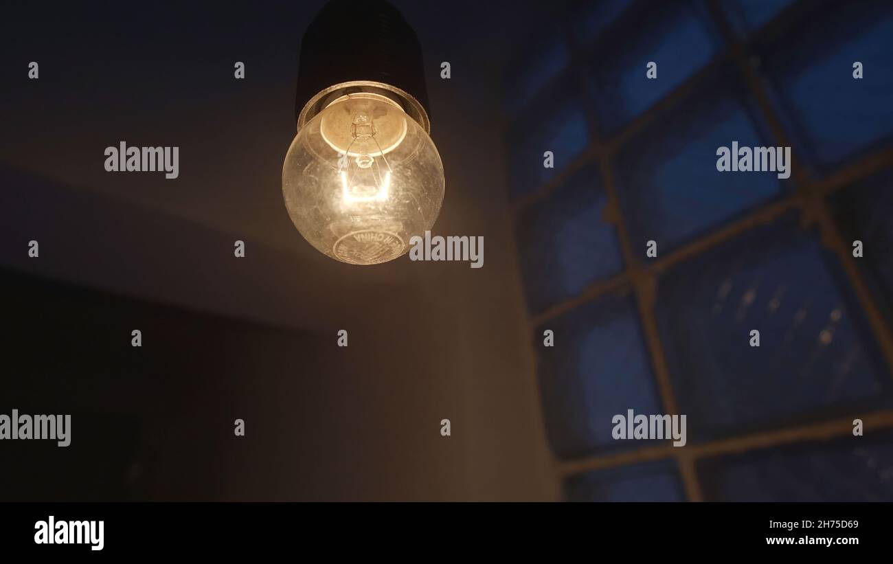 Light bulb without lamp hanging from the ceiling in the dark. Lighting ...
