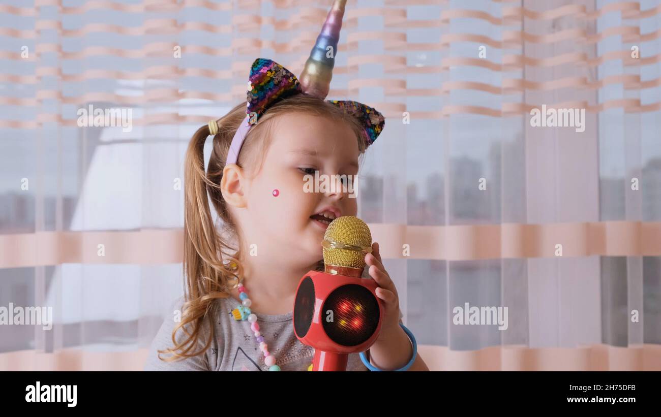 funny cute little girl 4-5 years old, singing into a karaoke microphone ...