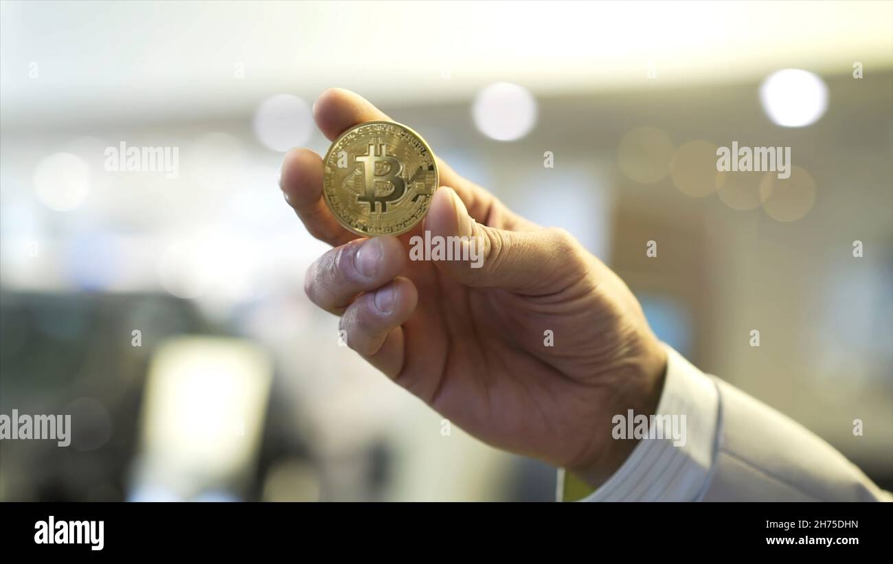 Businessman hand holding glowing bitcoin sign. Stock. Virtual money ...