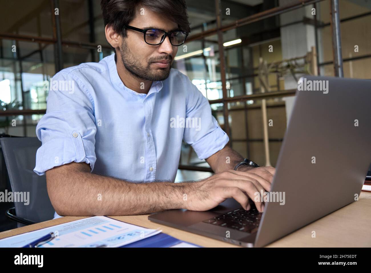 Young Indian business man using laptop computer working in office Stock ...