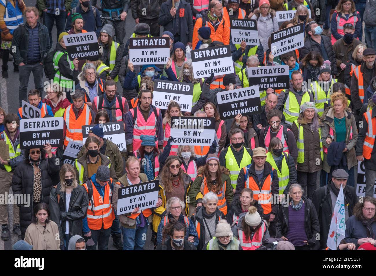 London, UK. 20th Nov 2021. People on the march hold posters 'Betrayed ...