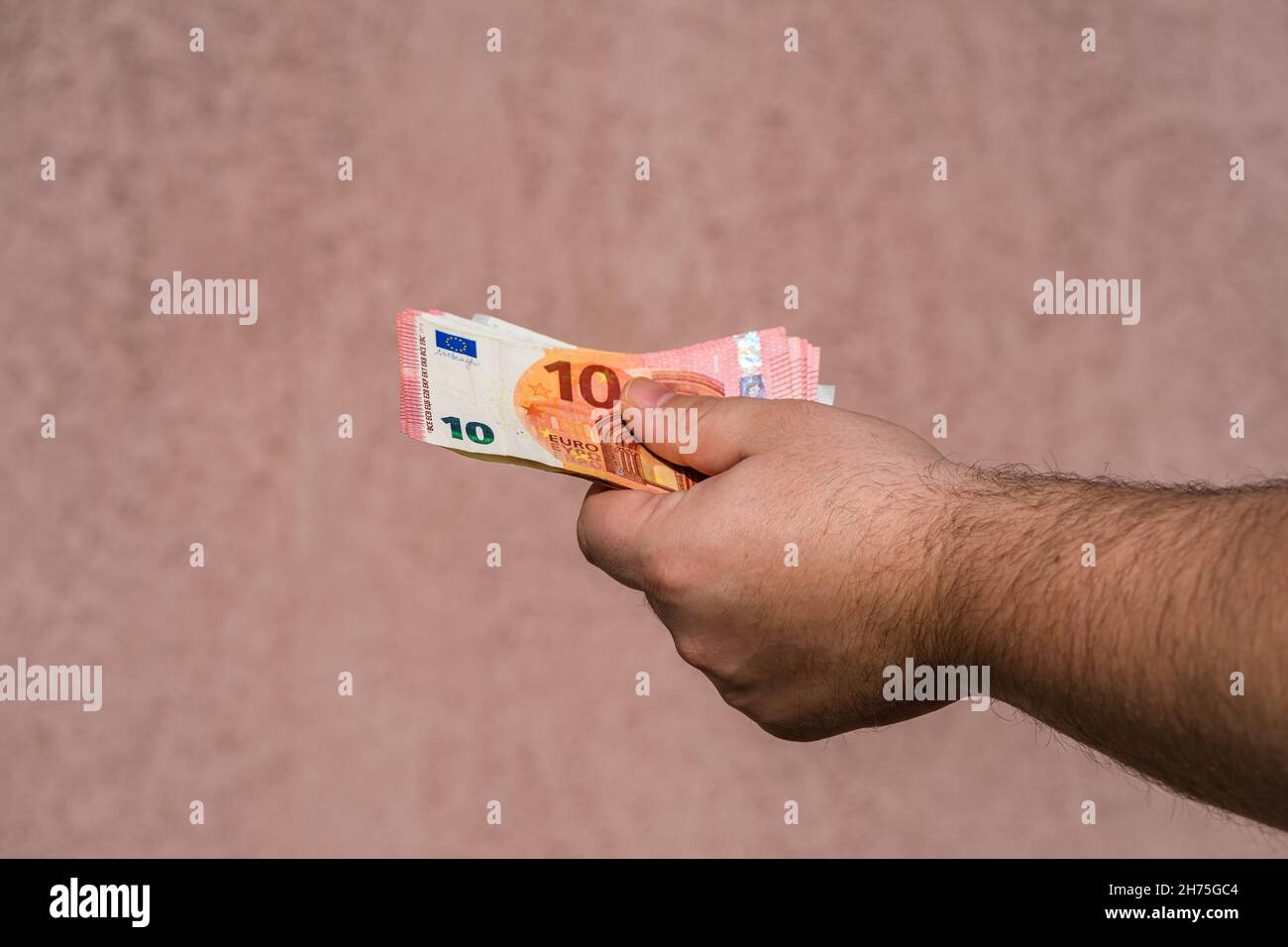 Hand holding showing 10 euro banknotes, giving or receiving money like ...