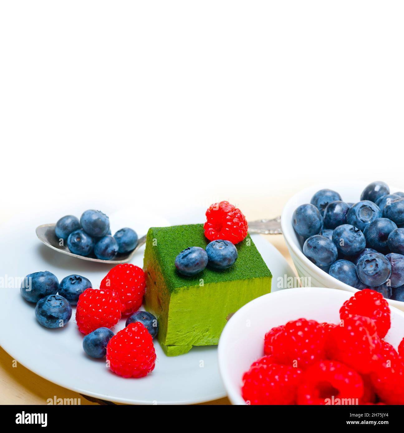 green tea matcha mousse cake with raspberries and blueberries on top ...