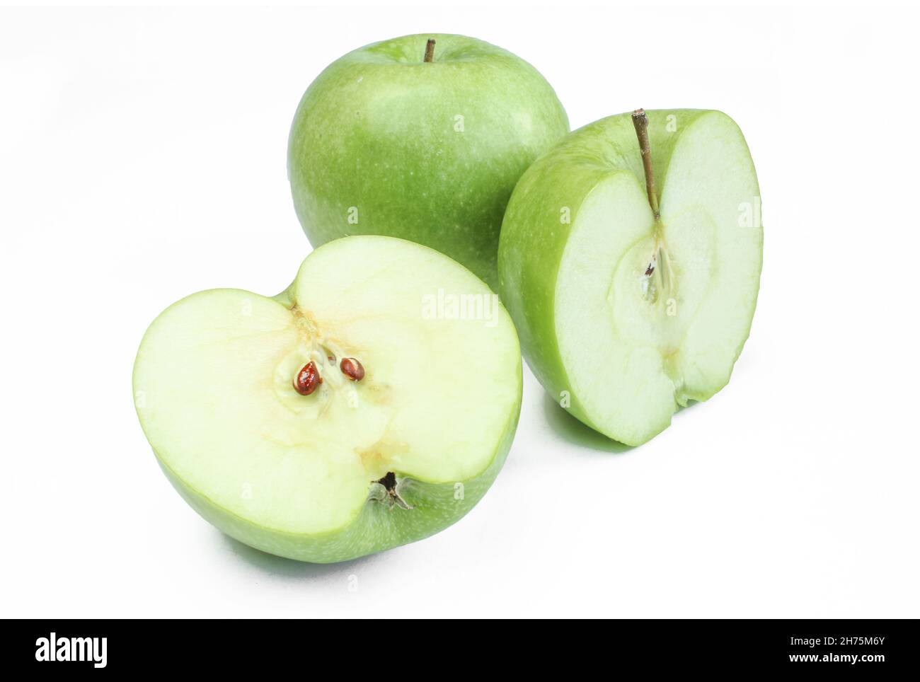 One whole and two half apples isolated on white background. Green fruit ...