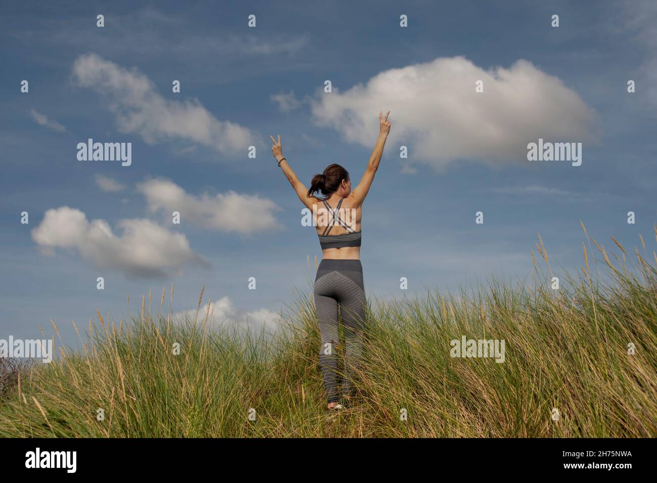 Woman athlete raising arms , rear view Stock Photo - Alamy