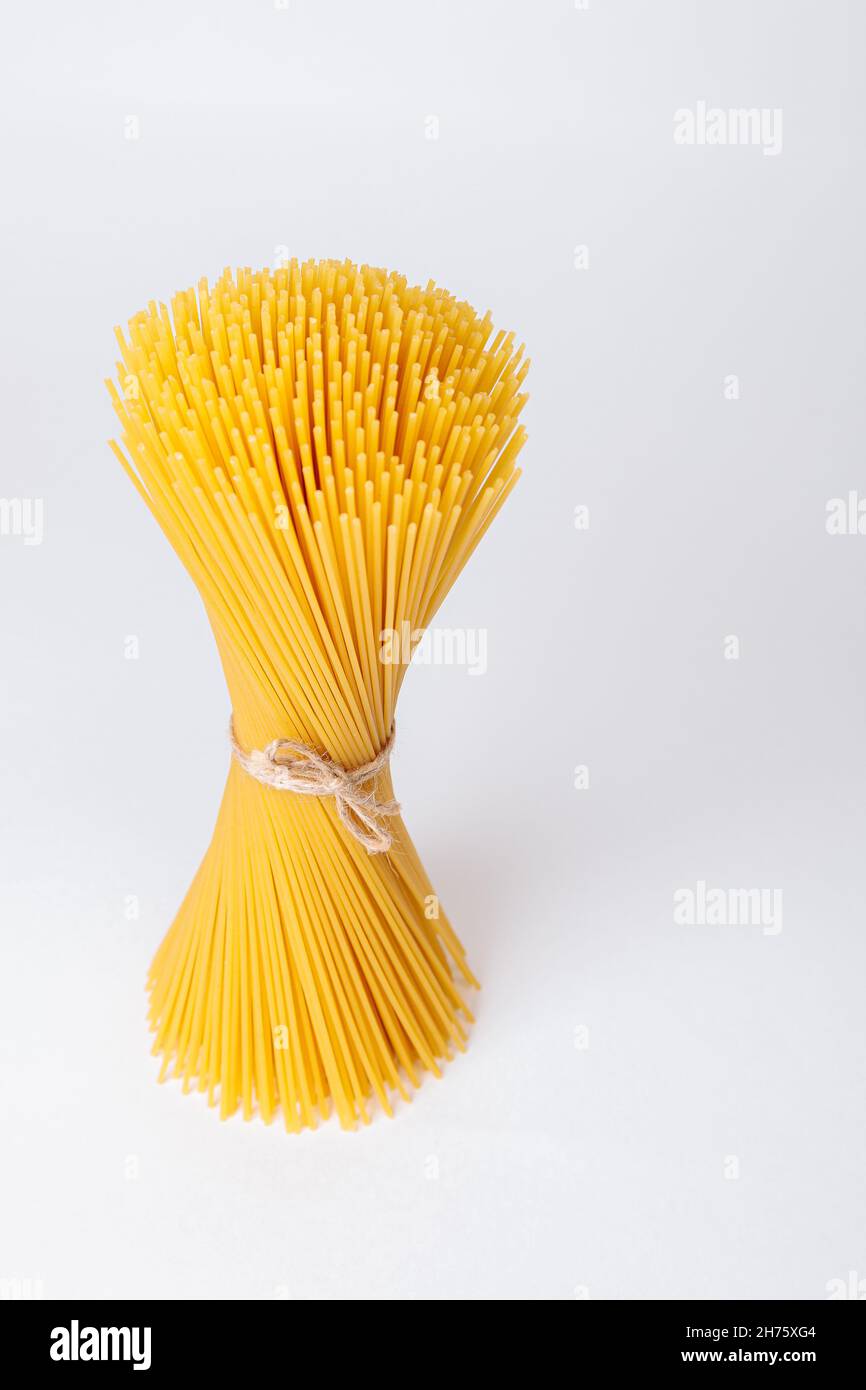 An upright bunch, a bunch of raw spaghetti tied with rope. Bundle on a ...
