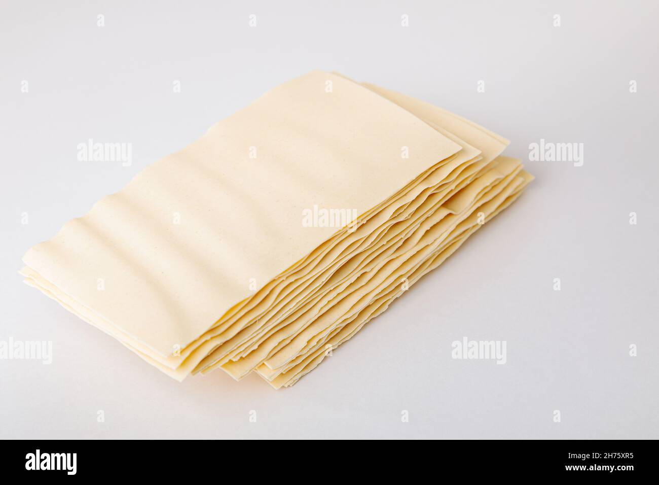 Raw lasagna. Dry dough sheets for lasagna on a white background ...